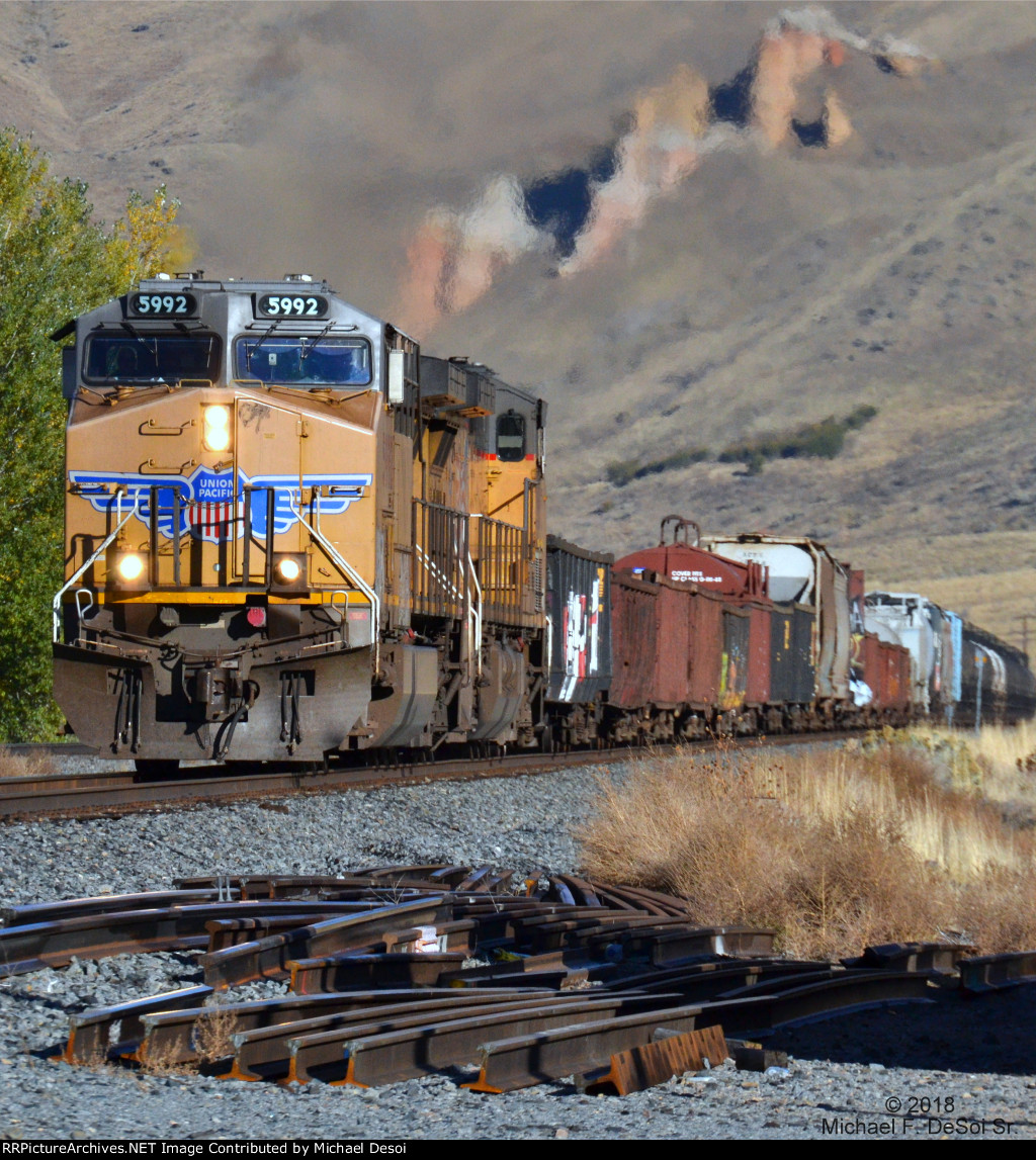 With the famous "Hoo Doos Of Echo" blurred by its exhaust, an eastbound UP freight (led by #5992 ...